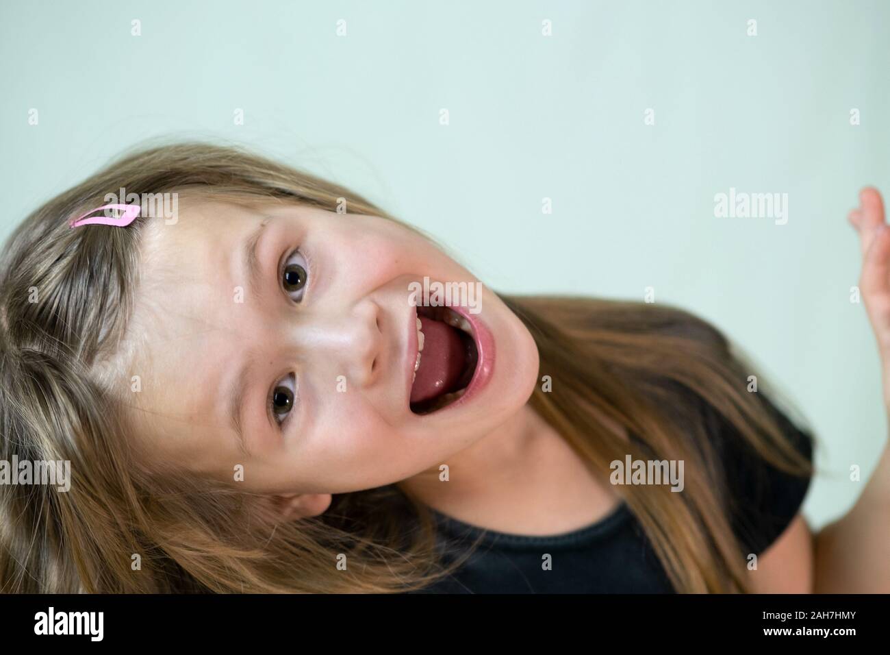 Close up portrait of fauuny angry shouting child girl with open mouth ...