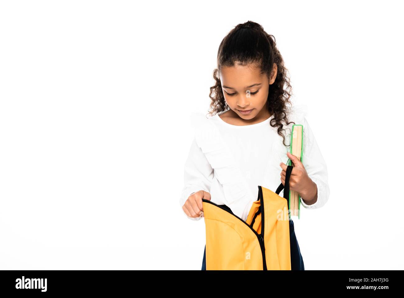 cute african american schoolgirl looking into backpack while holding ...