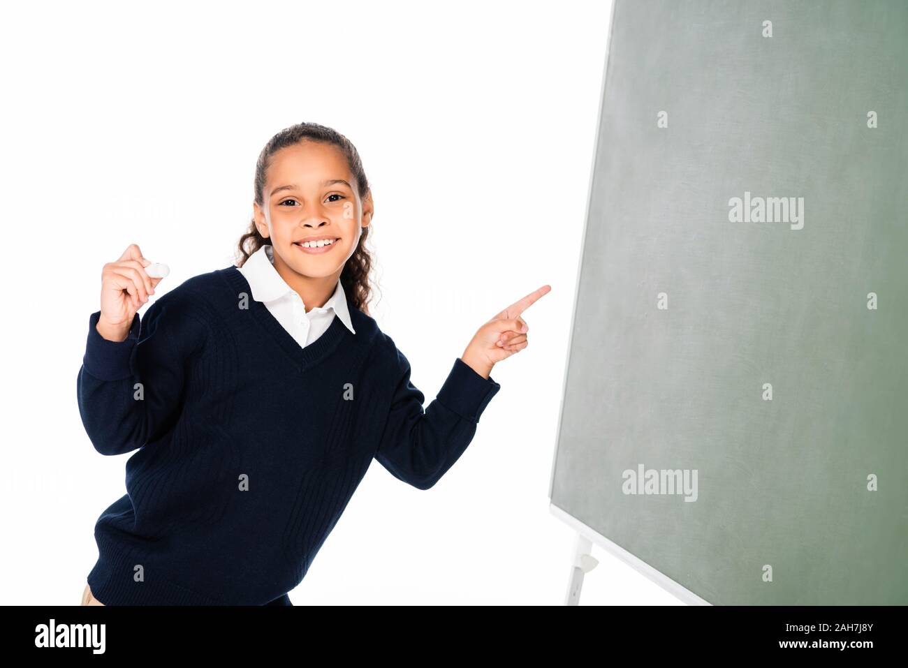 cheerful african american schoolgirl pointing with finger at green ...