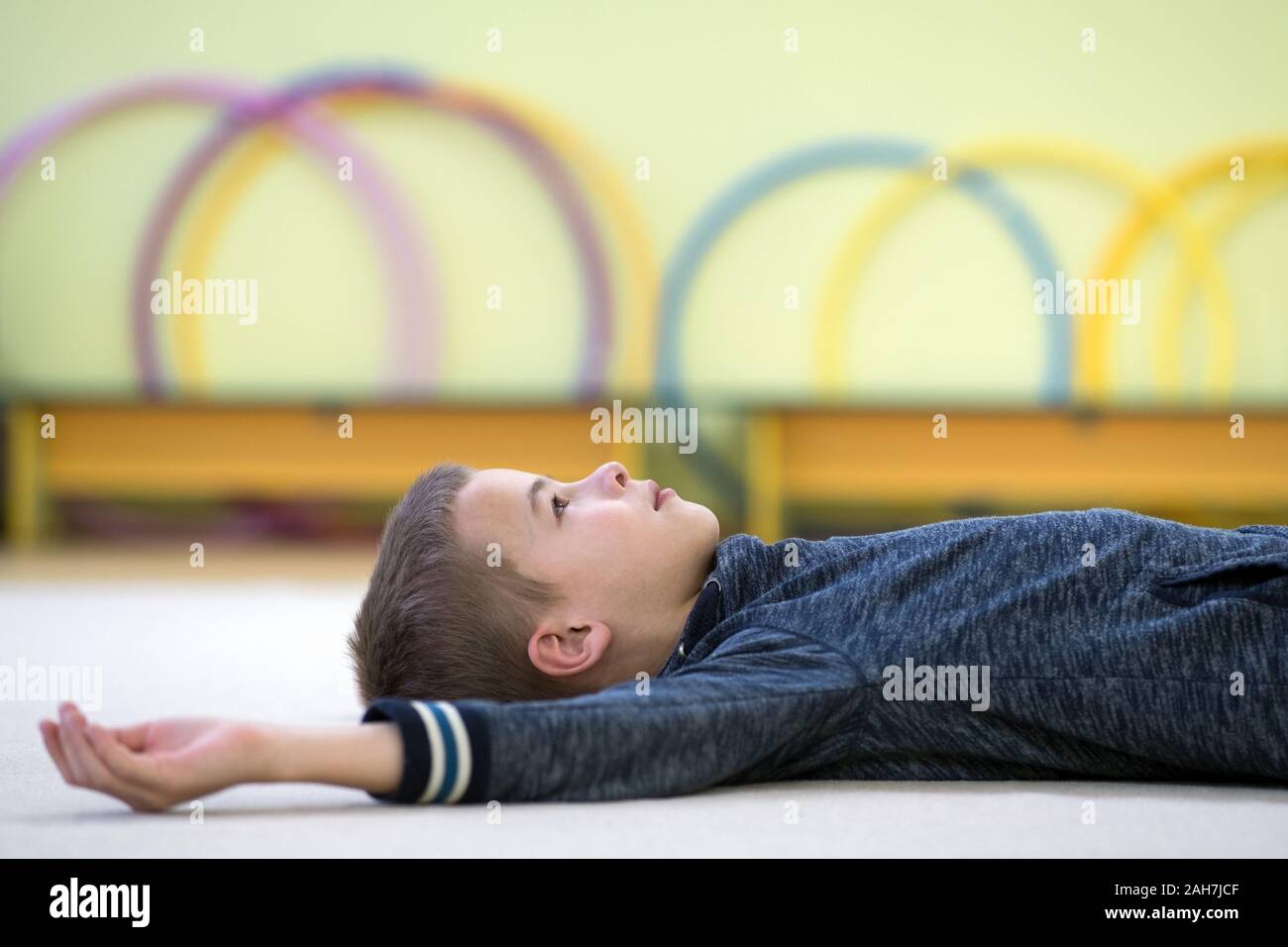 Young child boy laying down and relaxiong while resting on the floor ...