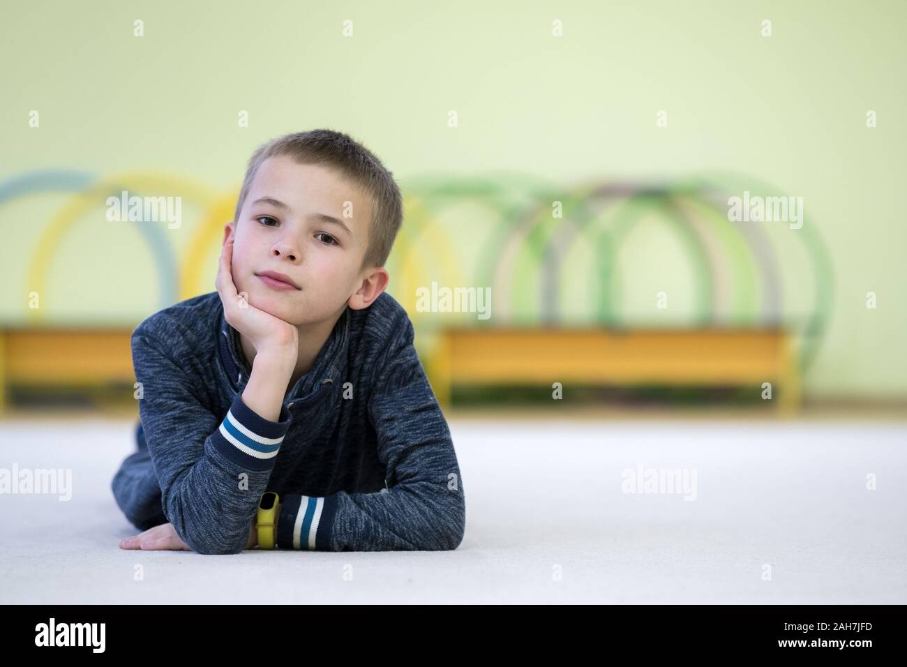 Young child boy laying down and relaxiong while resting on the floor ...