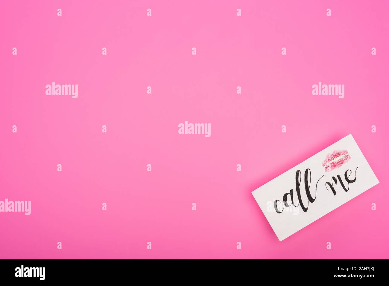 top view of card with lip print and call me lettering isolated on pink ...
