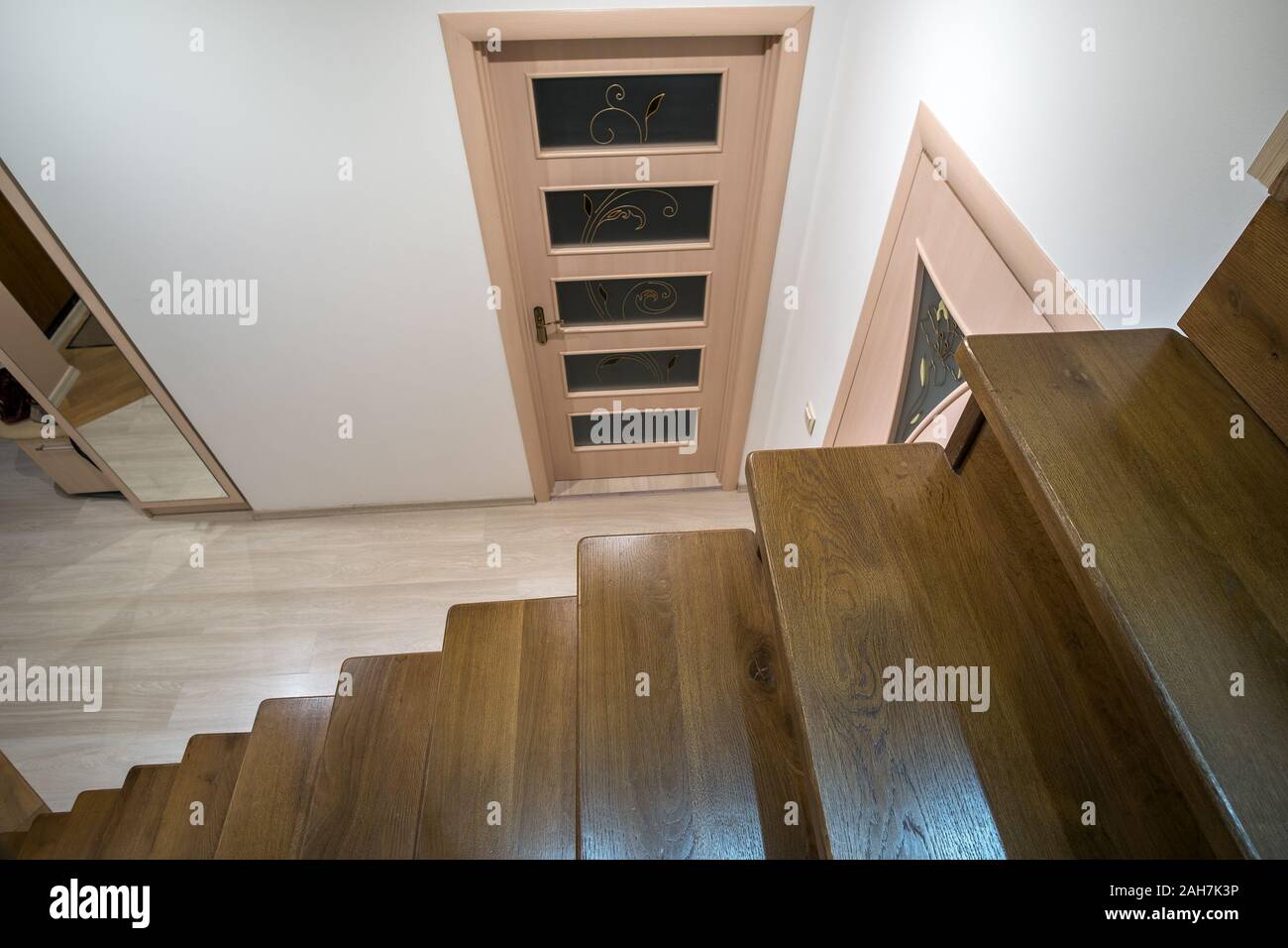 Interior of a house or appartment hallway with oak wooden stairs and ...