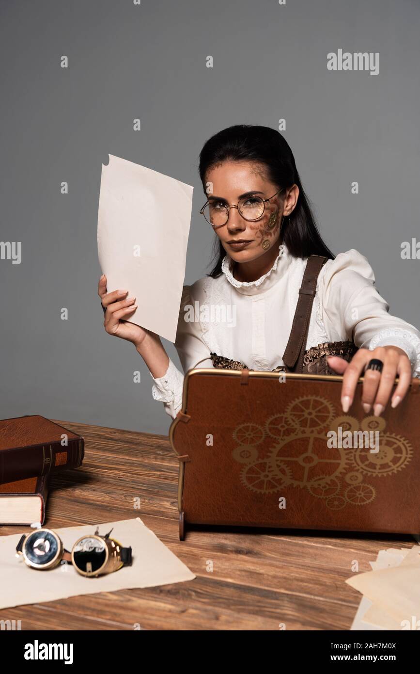 steampunk woman in glasses with documents and vintage laptop at ...