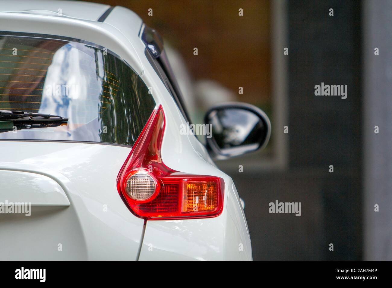 Rear lamp of a car parked near curb on the side of the street on a ...