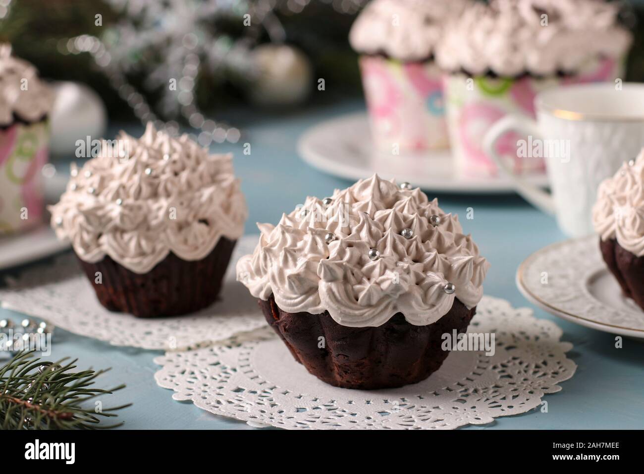 Homemade chocolate cupcakes with cream and a cup of coffee arranged on ...
