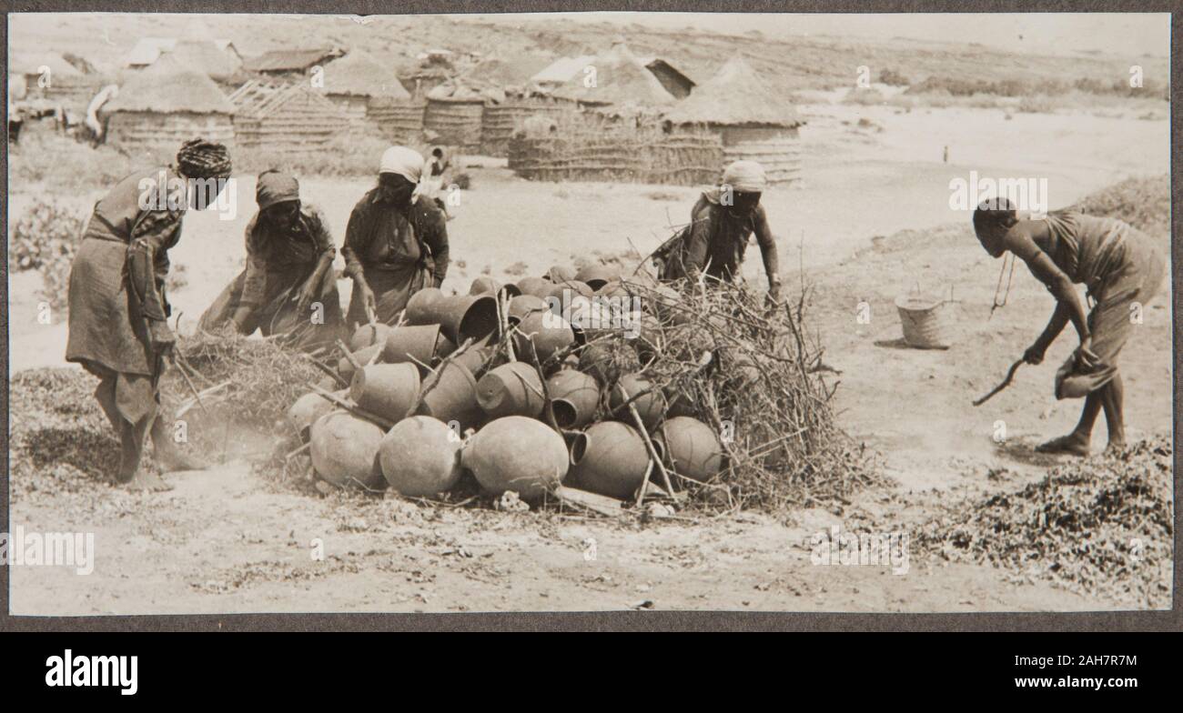 Somalia, A group of workers build a fire around recently thrown pots ...