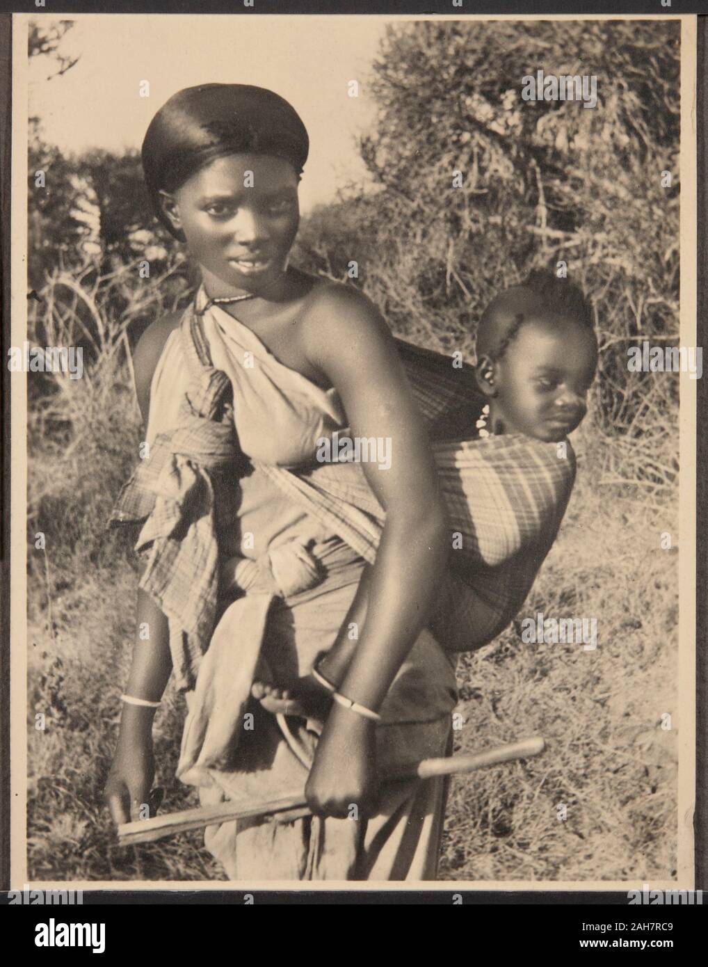Somalia, Portrait of a Somali woman with sticks in her hand and a baby ...