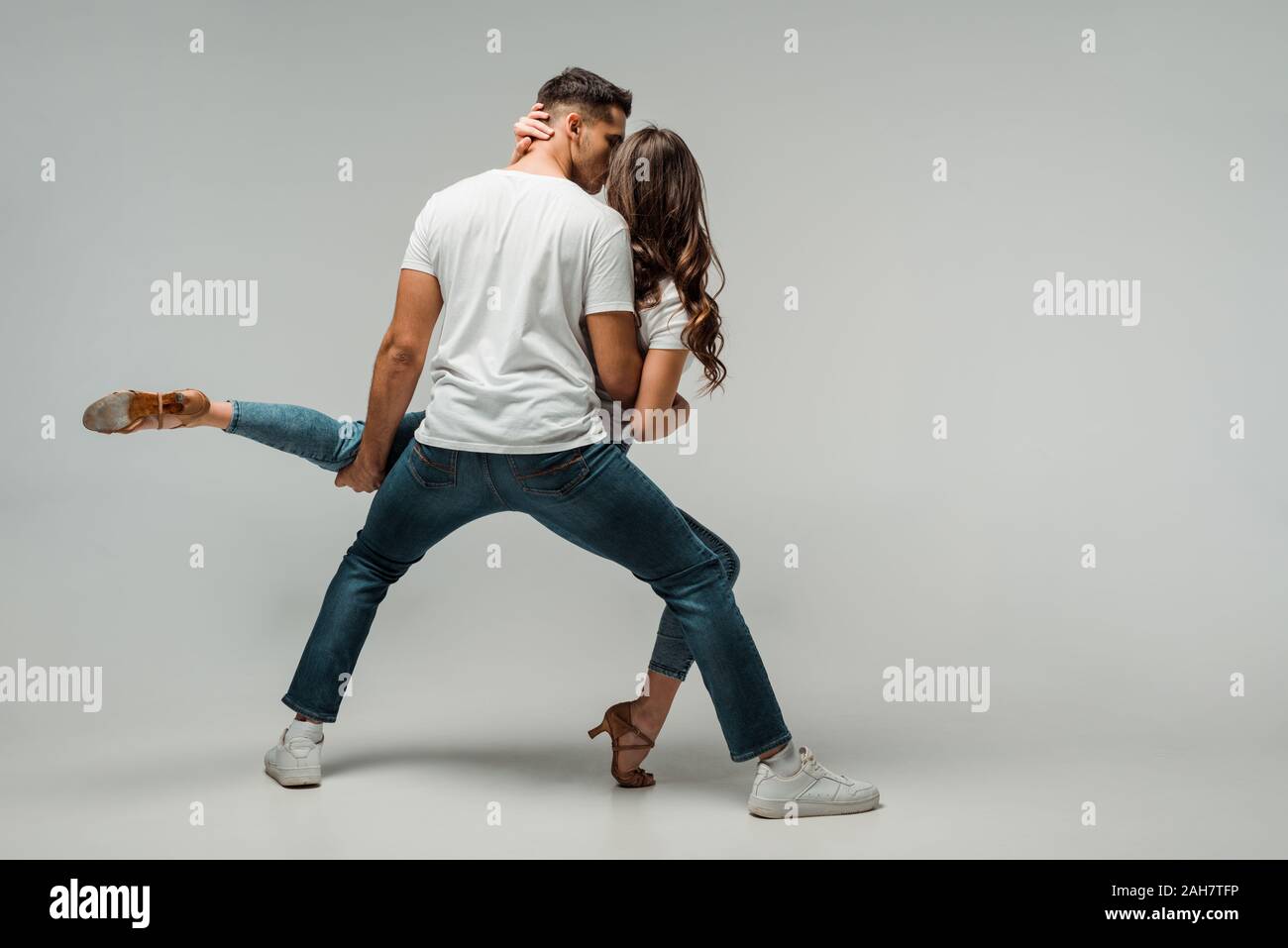 back view of dancers dancing bachata on grey background with copy space ...