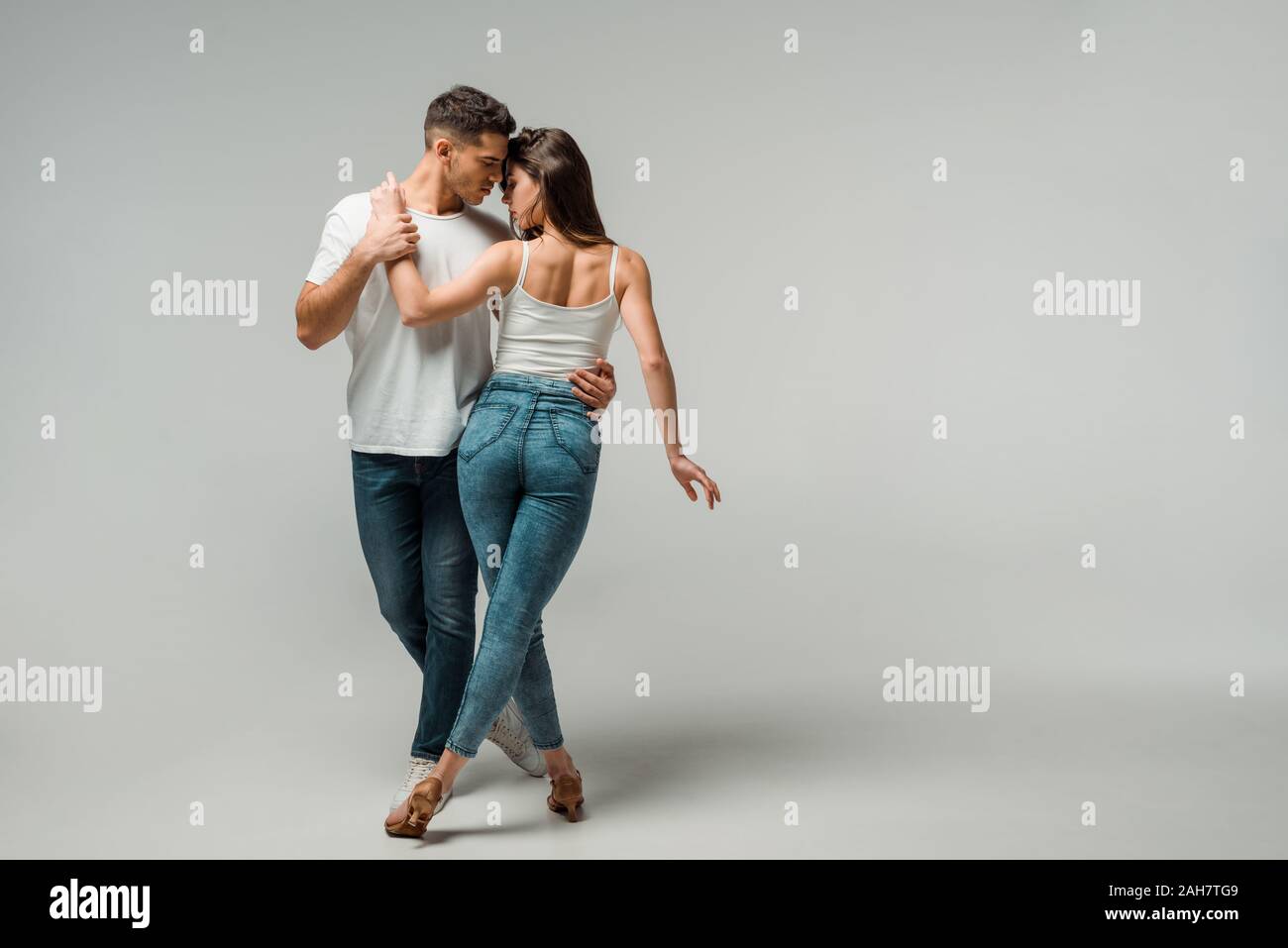 dancers in denim jeans dancing bachata on grey background Stock Photo ...