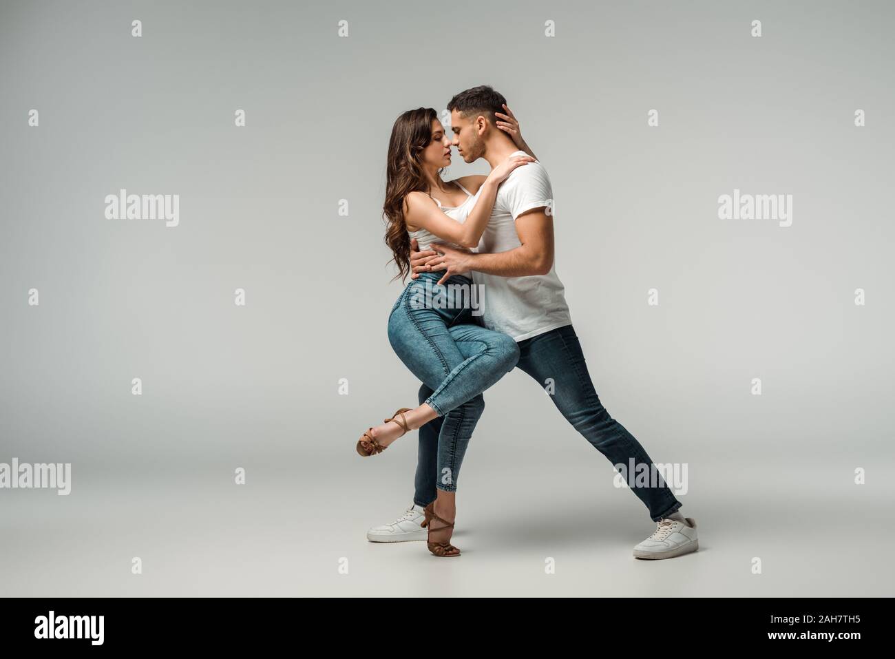 dancers in denim jeans dancing bachata on grey background Stock Photo ...