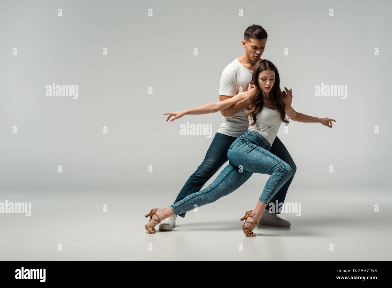 dancers in denim jeans dancing bachata on grey background Stock Photo ...