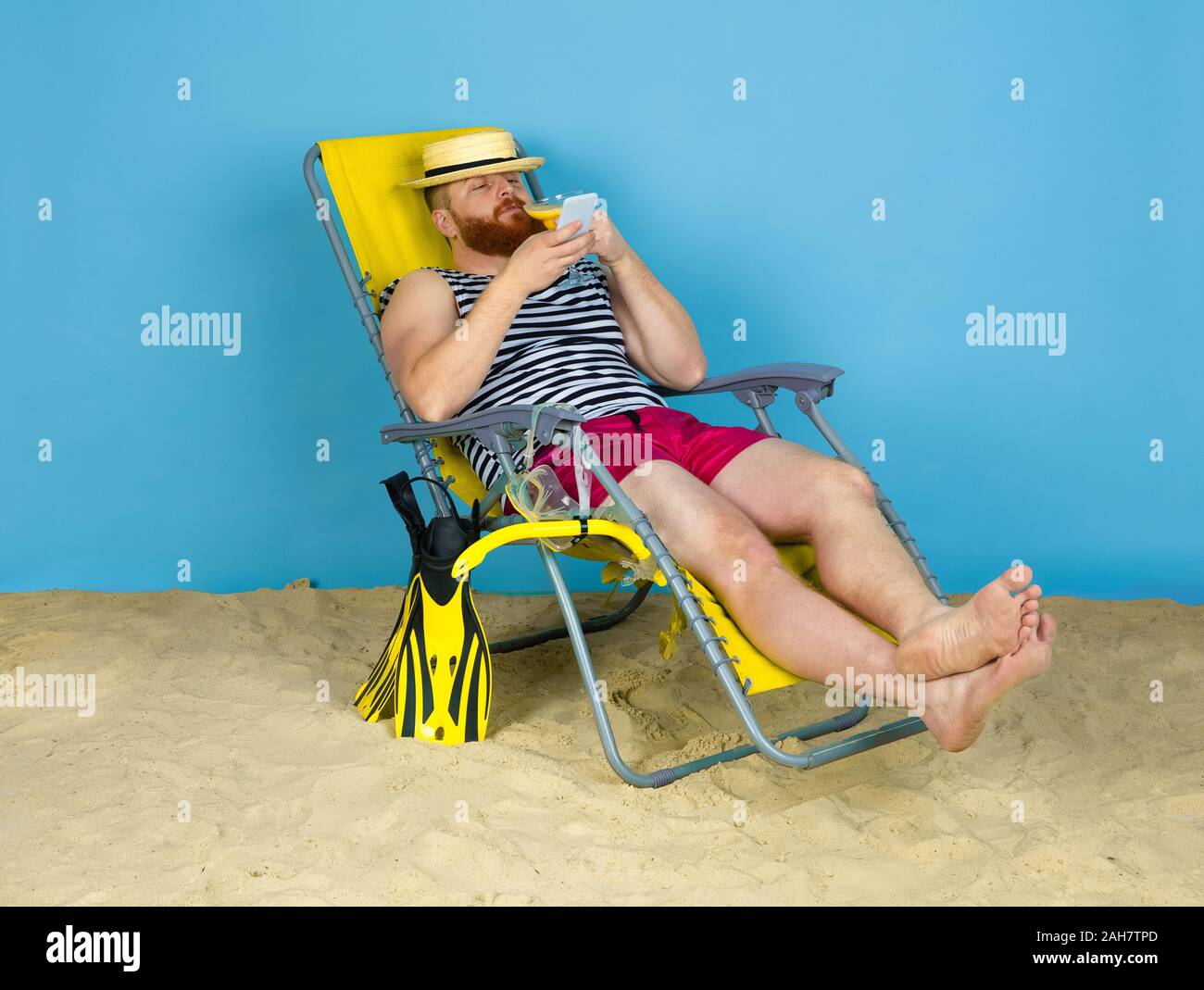 Happy young man resting, takes selfie, drinking cocktails on blue ...