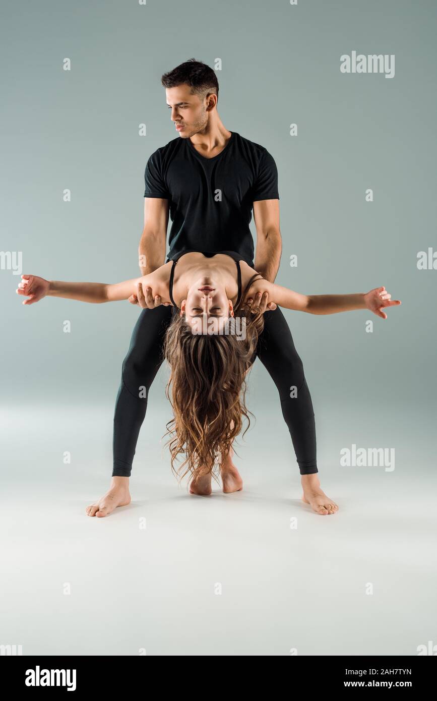 handsome and attractive dancers dancing contemporary on grey background ...