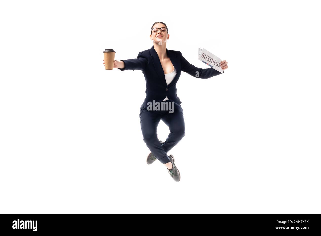 elegant businesswoman dancing while holding coffee to go and newspaper ...
