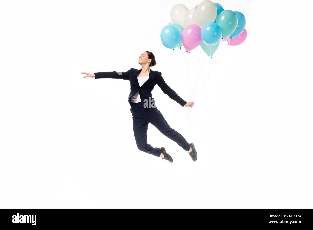 happy businesswoman levitating with festive balloons isolated on white ...