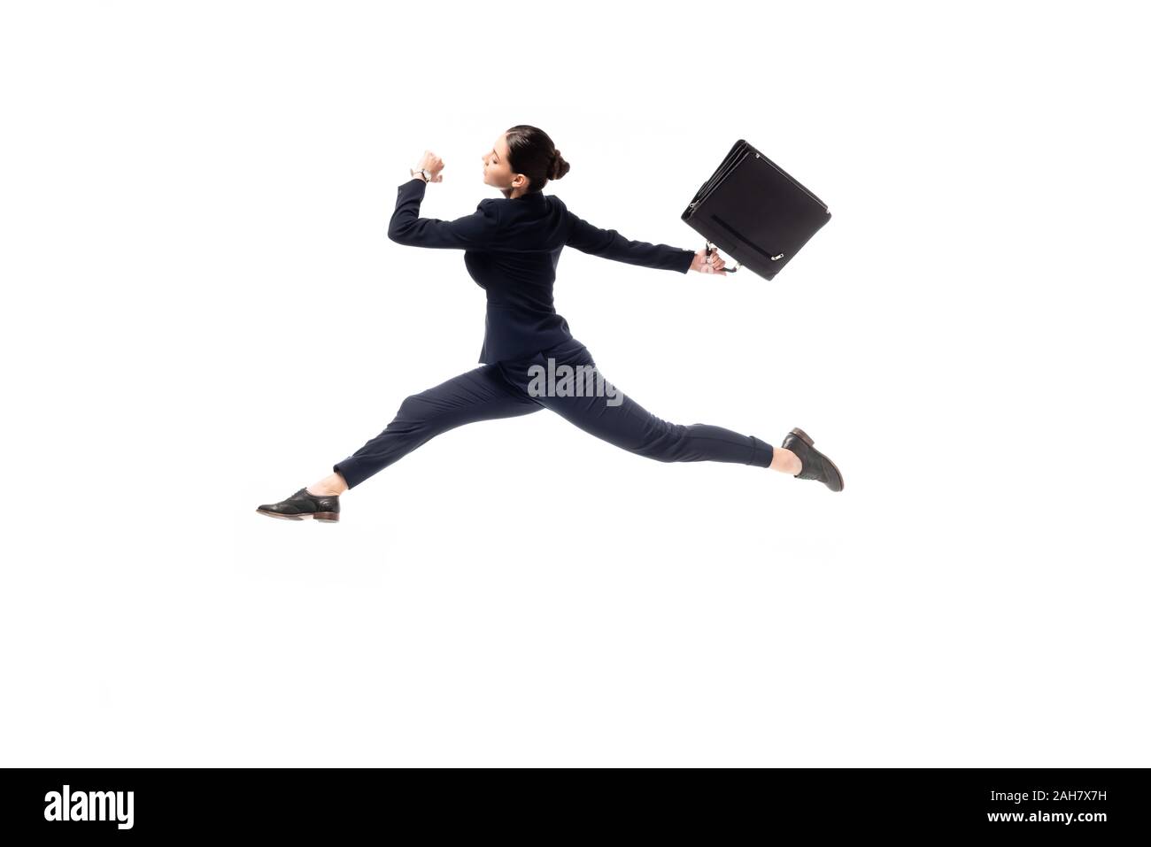side view of young businesswoman with briefcase jumping in dance ...