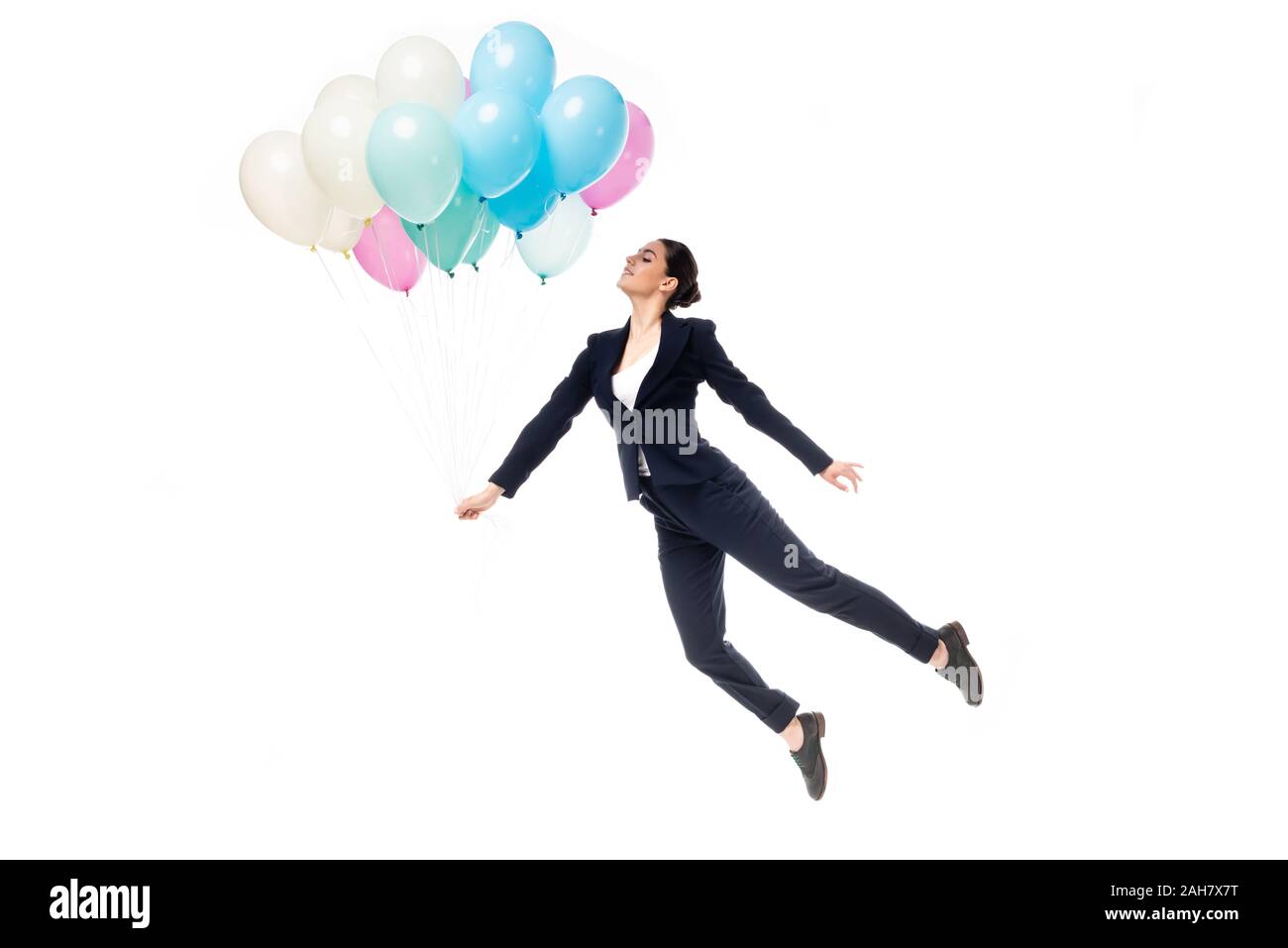 happy businesswoman in formal wear levitating with festive balloons ...