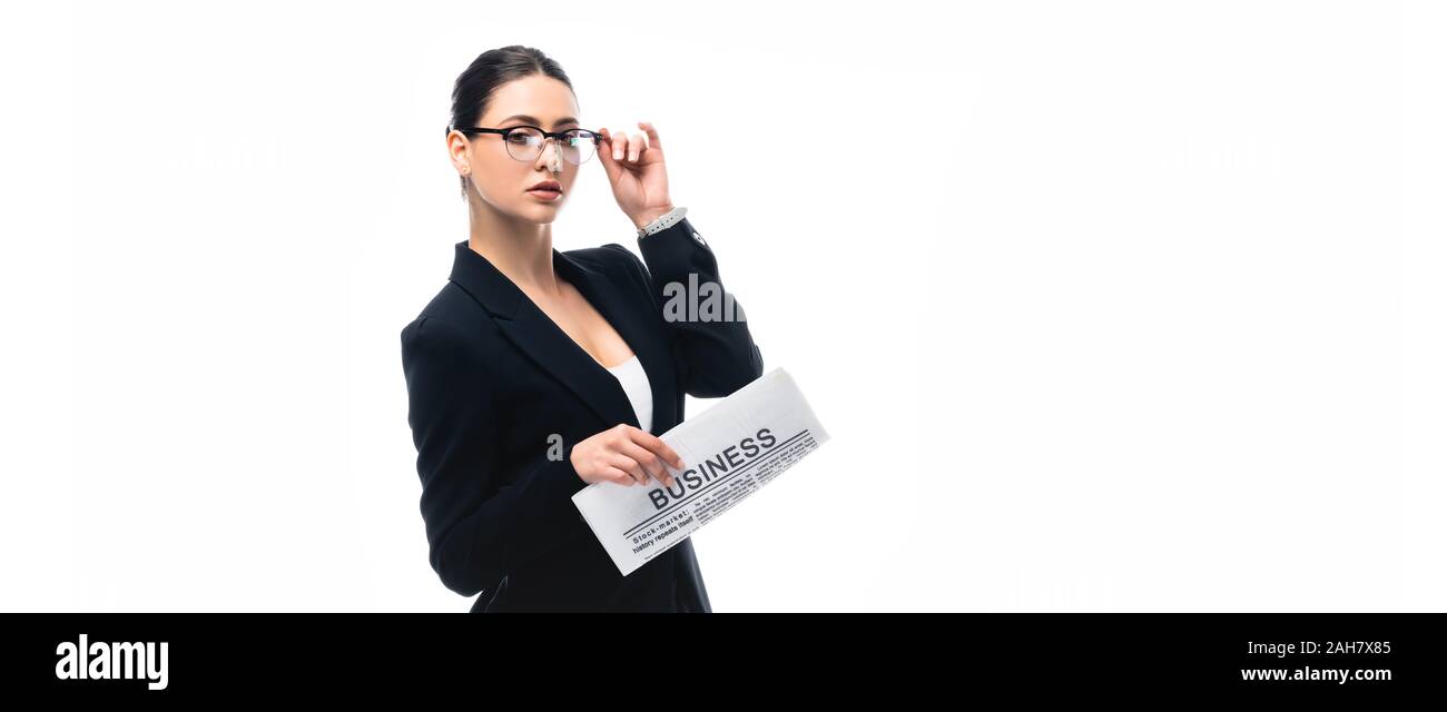 panoramic shot of serious businesswoman holding business newspaper and ...