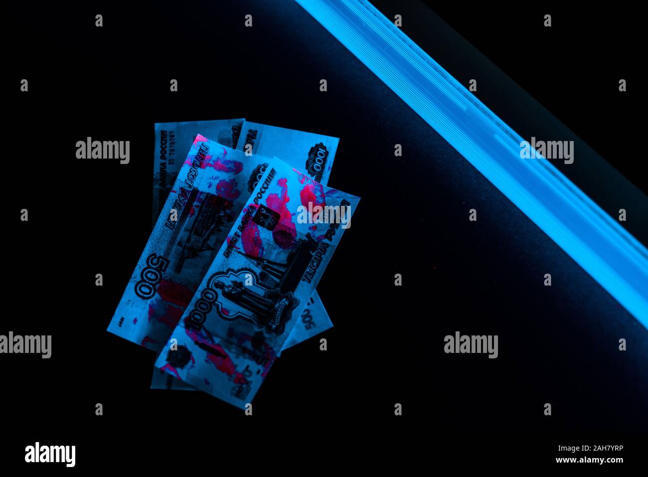 top view of blue ultraviolet lightning on russian money on black Stock ...