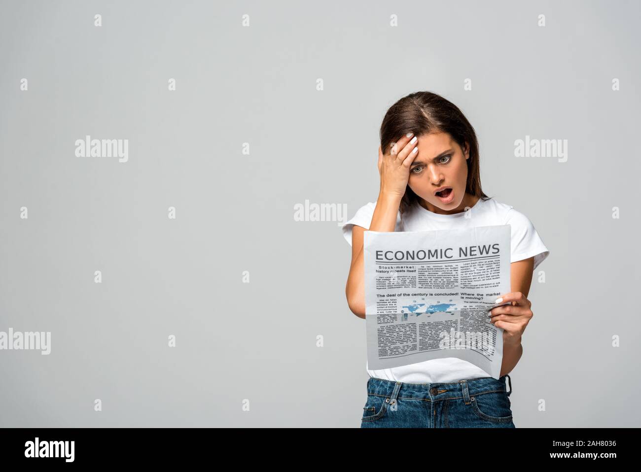 beautiful shocked woman reading economic newspaper, isolated on grey ...