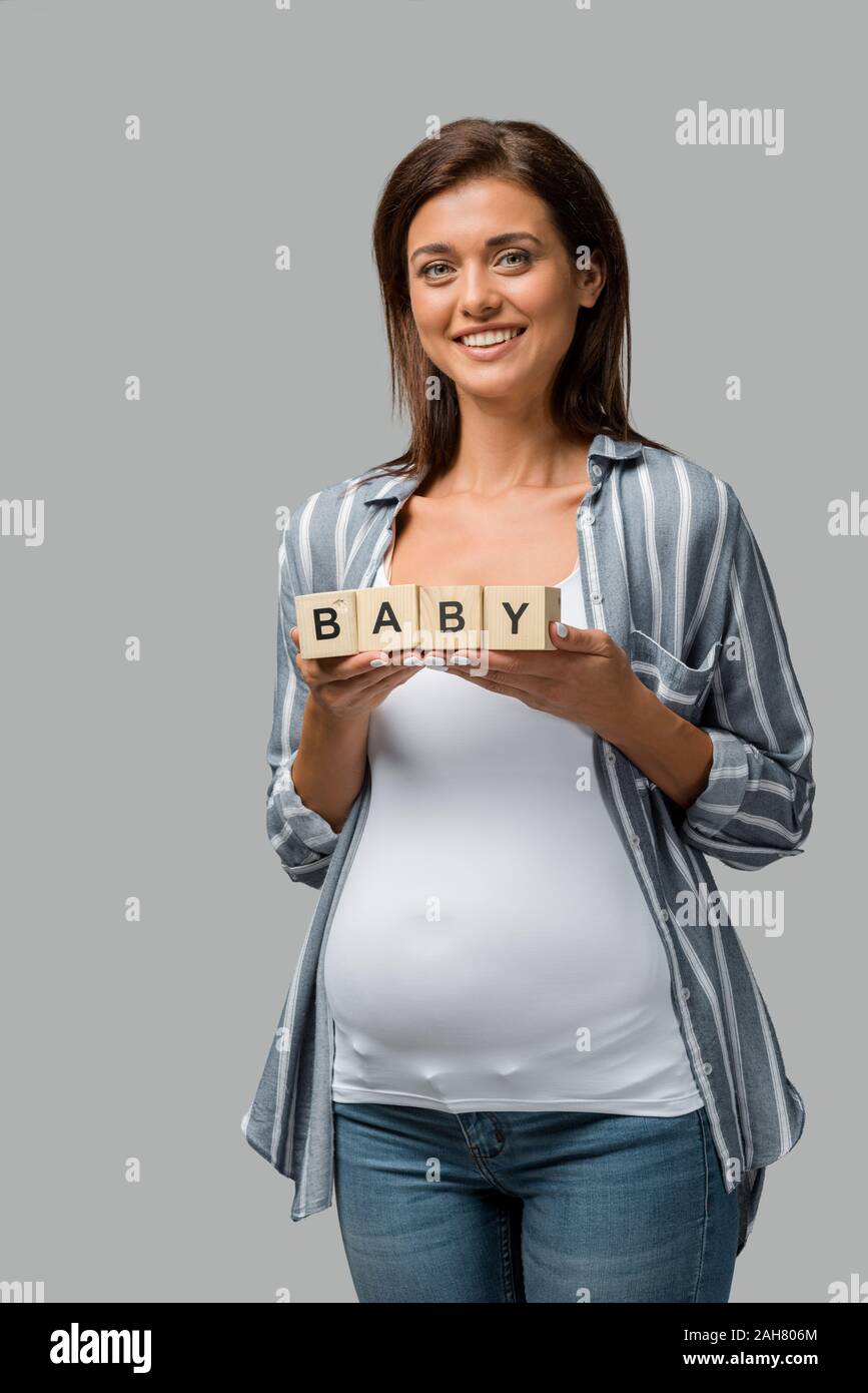 beautiful smiling pregnant woman holding alphabet cubes with baby sign ...