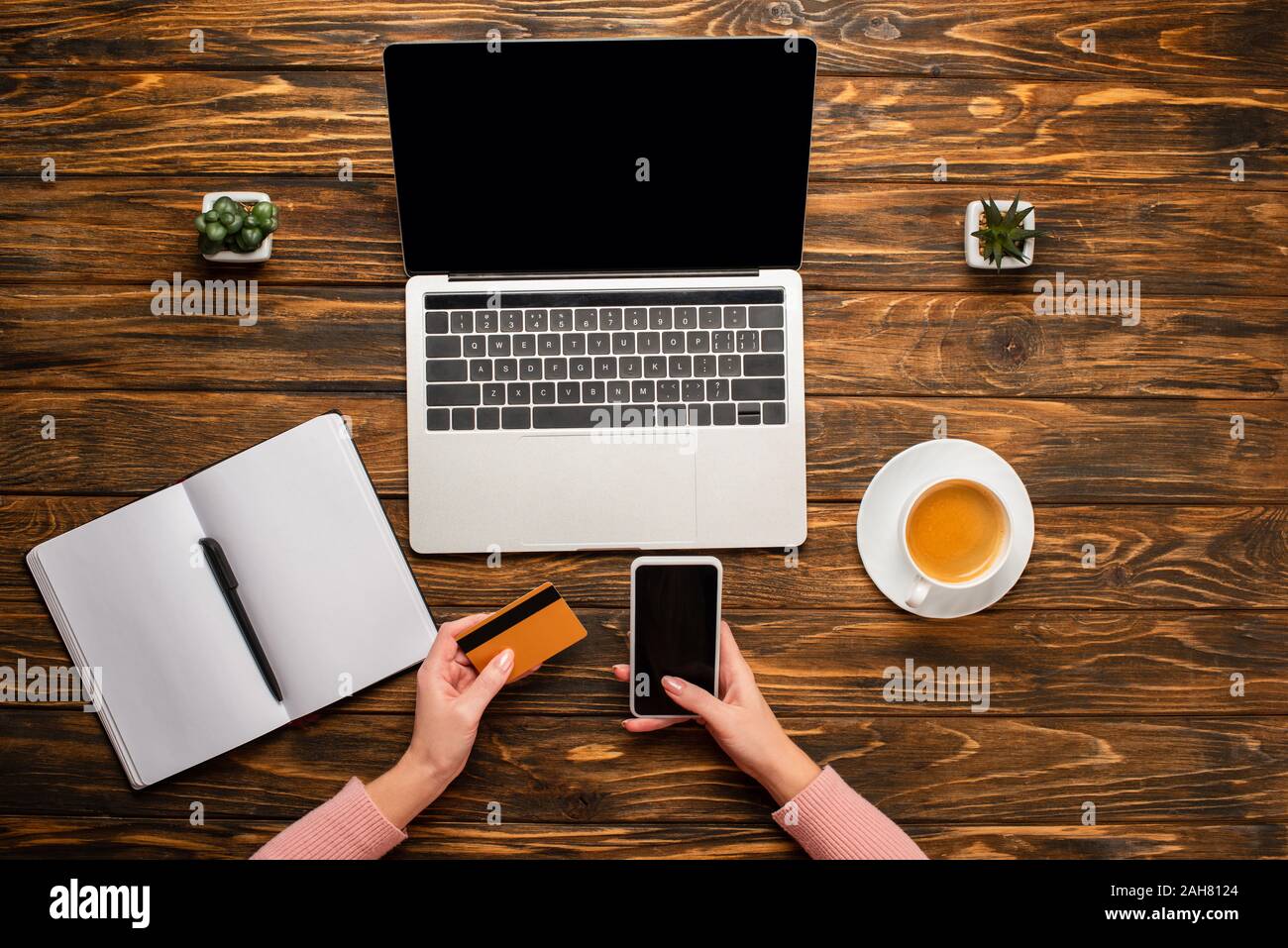 cropped view of businesswoman holding smartphone and credit card near ...