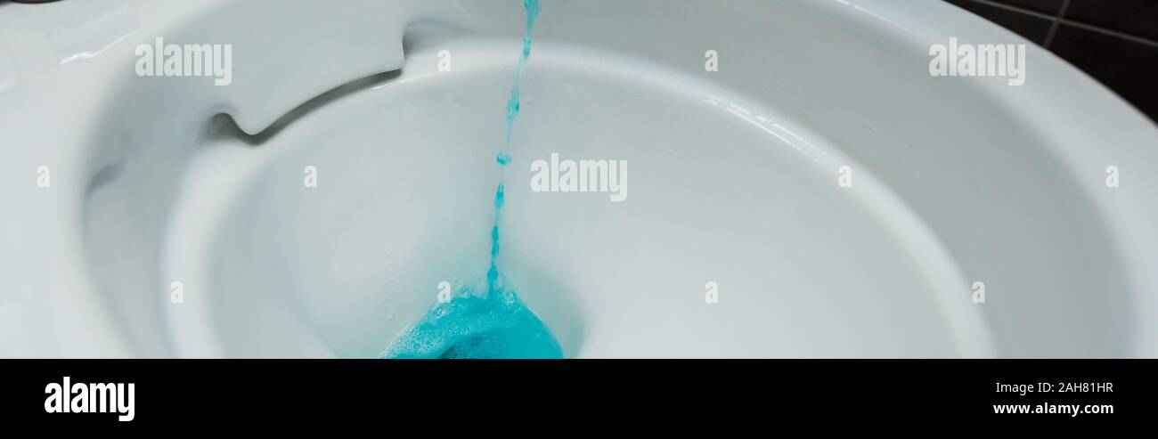 close up view of blue liquid detergent pouring into ceramic clean ...