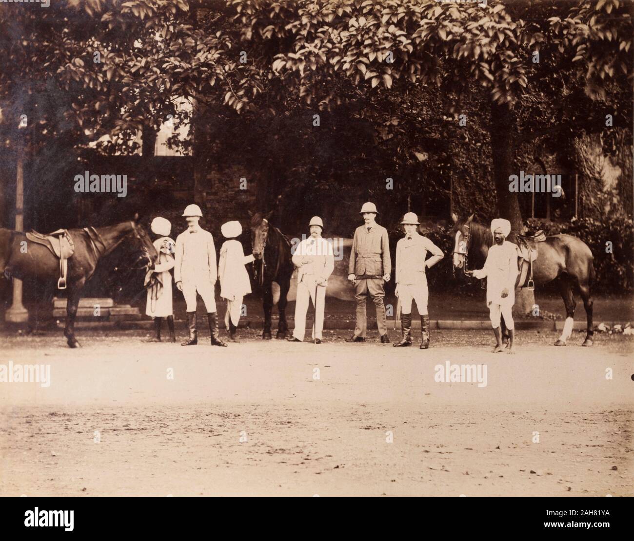 India, Four British men pose for the camera, their Indian servants ...