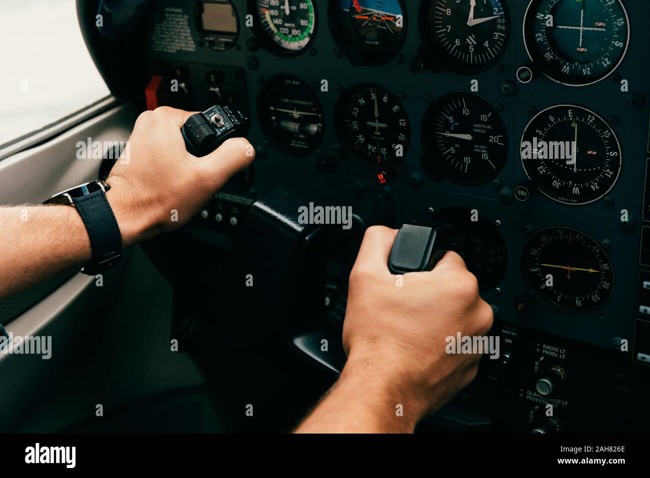 partial view of pilot in wristwatch holding helm in plane Stock Photo ...