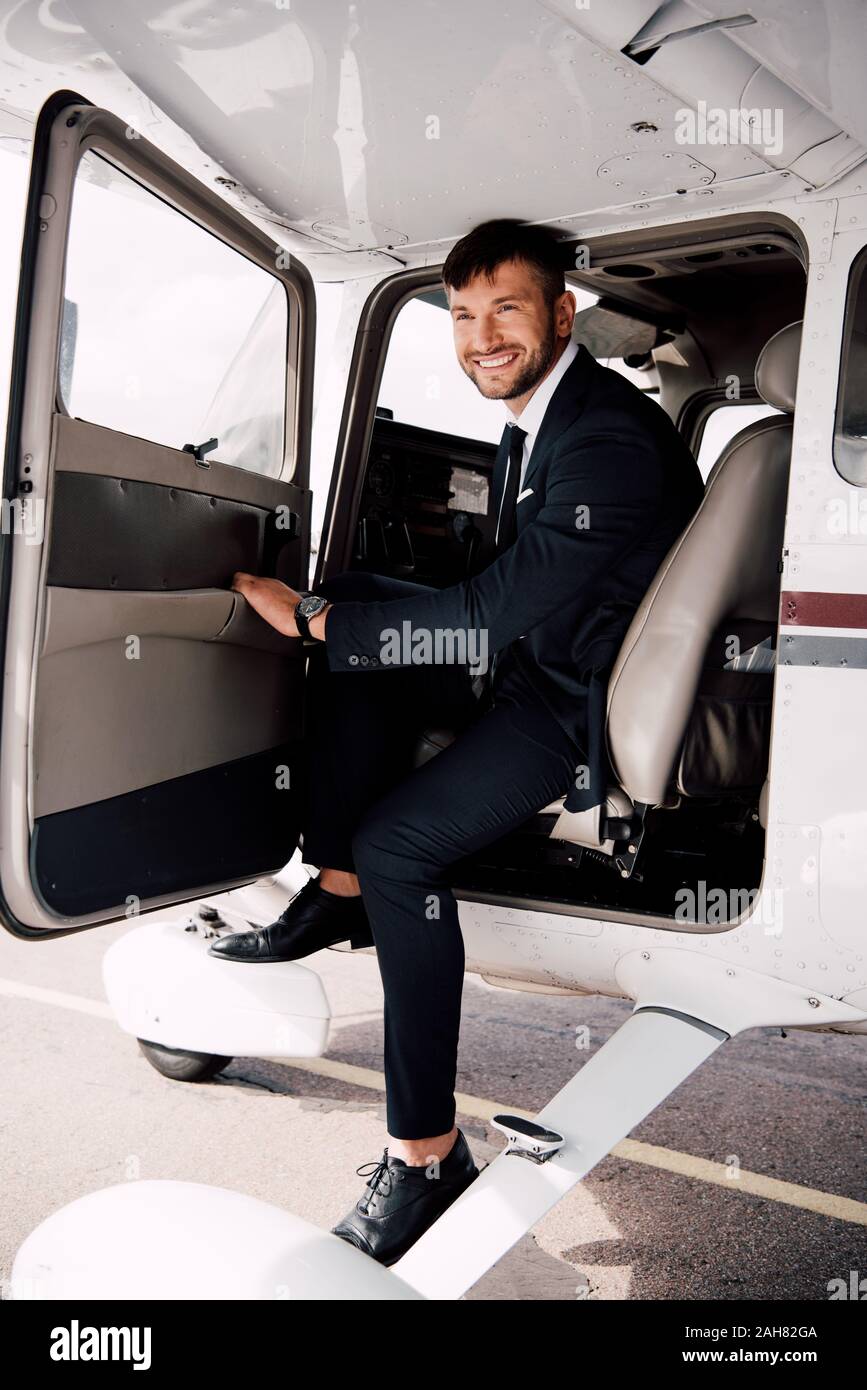 smiling bearded businessman in formal wear sitting in plane Stock Photo ...