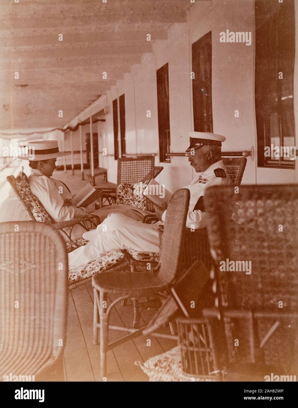 The Duke and Duchess of Connaught sit in lounge chairs, reading books ...