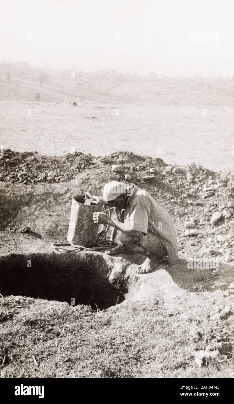 Kenya, A labourer squats at the opening to a mine shaft on the Kakamega ...