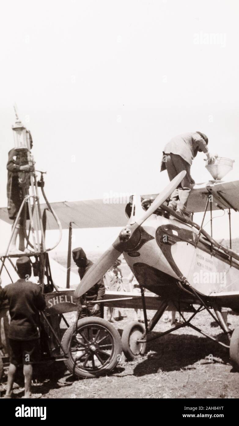 Kenya, Men refuel a East African Airways biplane at an airfield in ...