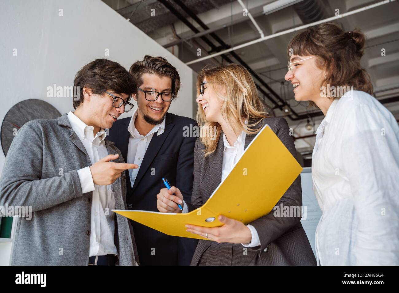Group of inspired young people standing and discussing new project ...