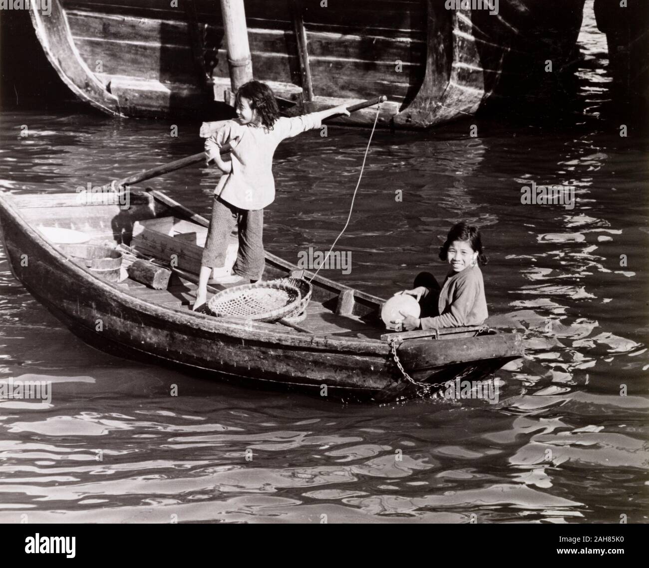 Hong Kong, Chinese girls steer a sampanTwo girls travel aboard a scull ...