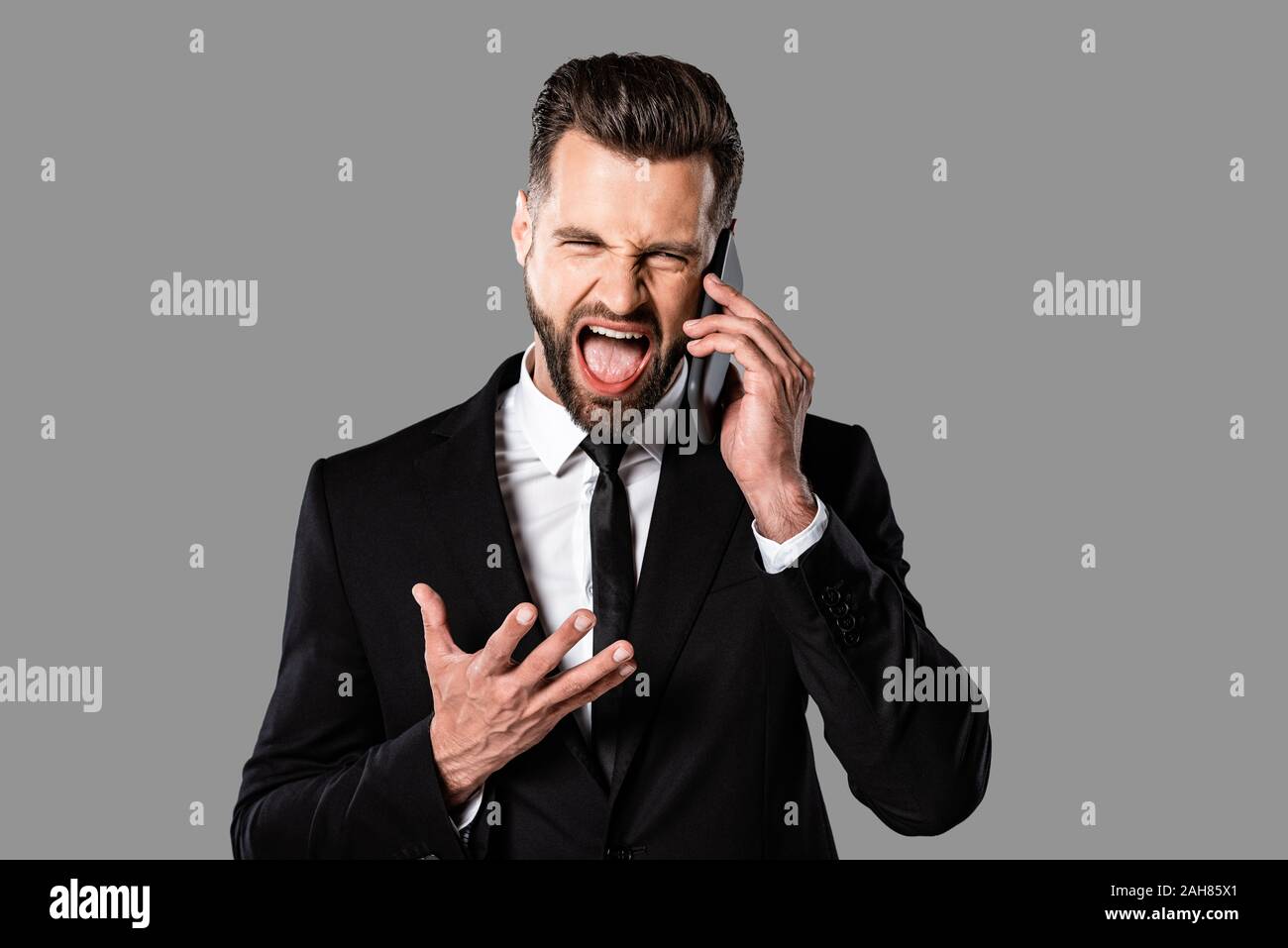 aggressive boss in black suit yelling while talking on smartphone ...