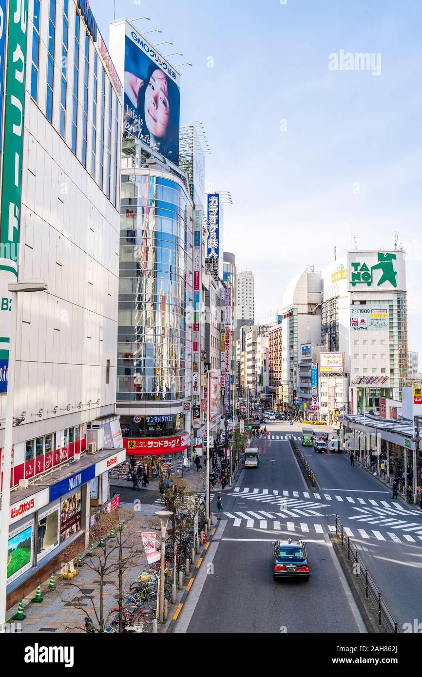 View along a shopping stgreet in Shinjuku, Tokyo. One side with high ...