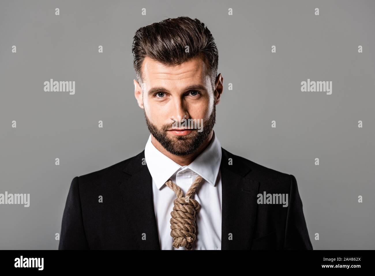 depressed businessman in black suit with noose on neck isolated on grey ...