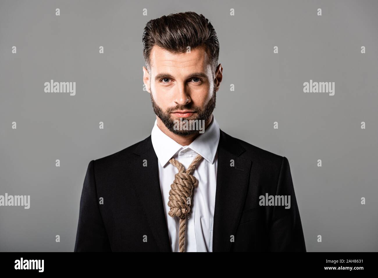 depressed handsome businessman in black suit with noose on neck ...
