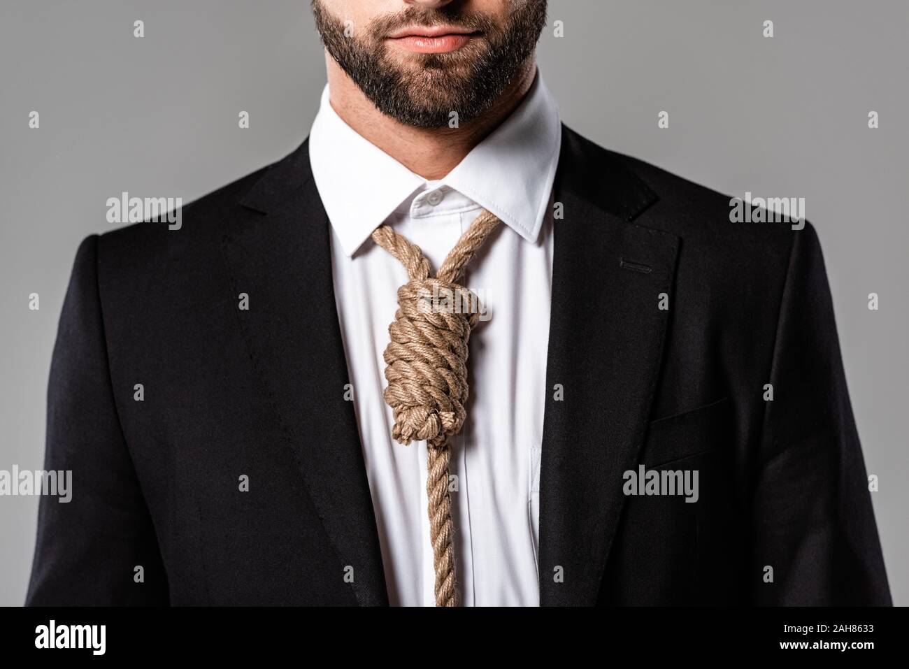 partial view of depressed businessman in black suit with noose on neck ...