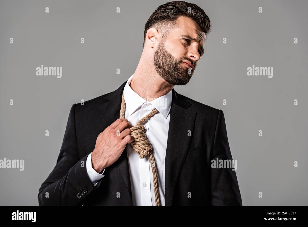 depressed businessman in black suit touching noose on neck isolated on ...