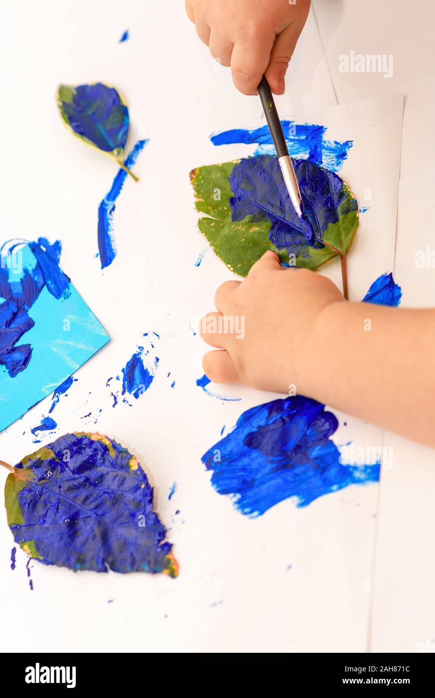 Little child painting leaves blue, arts and crafts. Classic Leaf ...