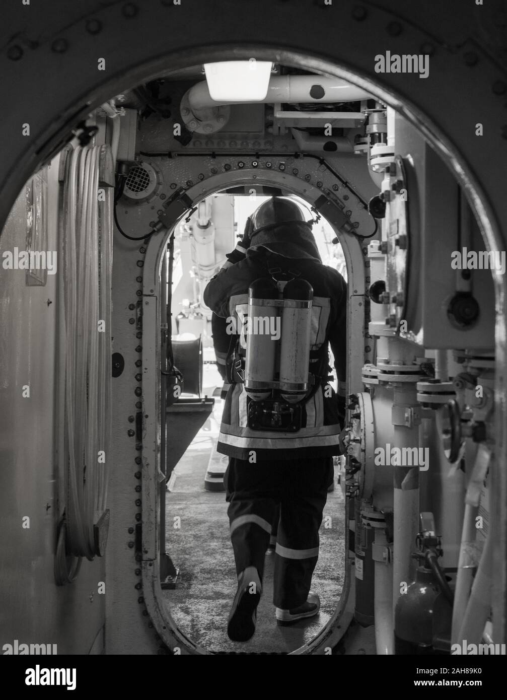 Fireman in uniform and oxygen mask going outside of ship Stock Photo ...