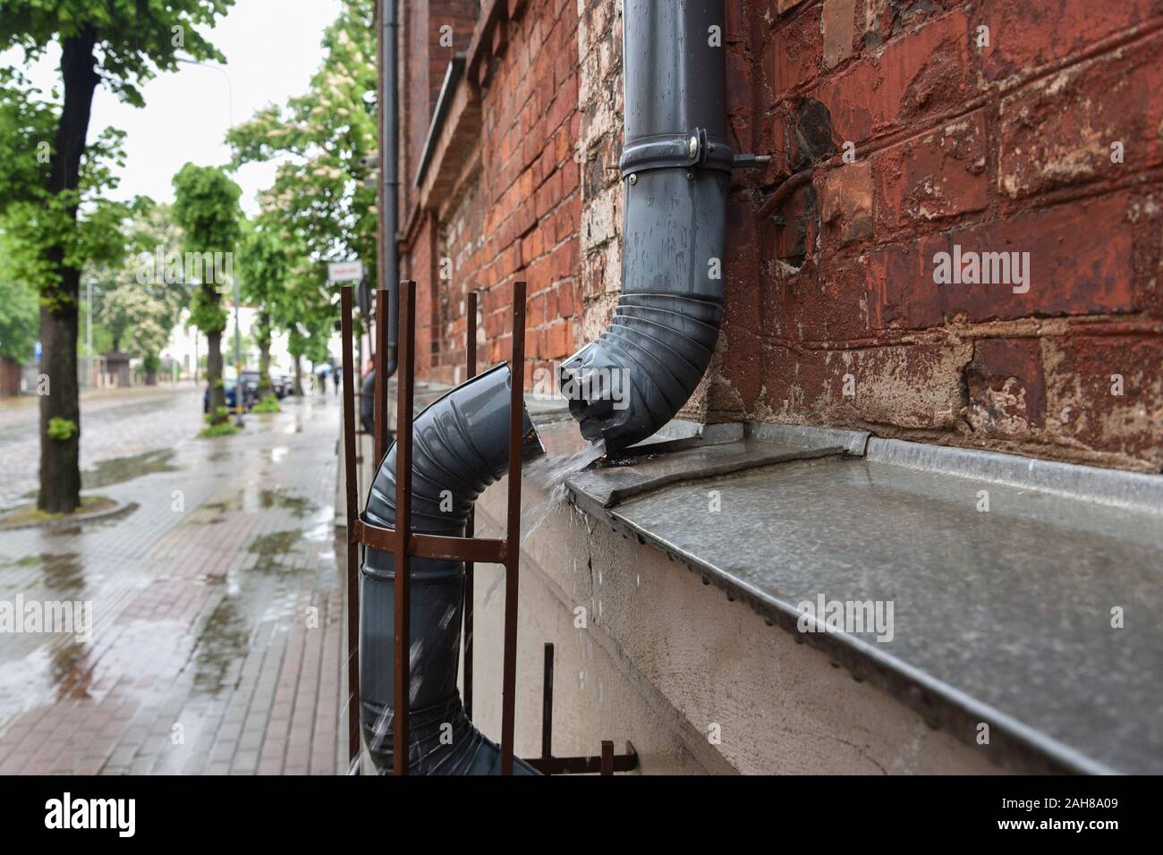 Rain water flowing from damage metal gutter Stock Photo - Alamy