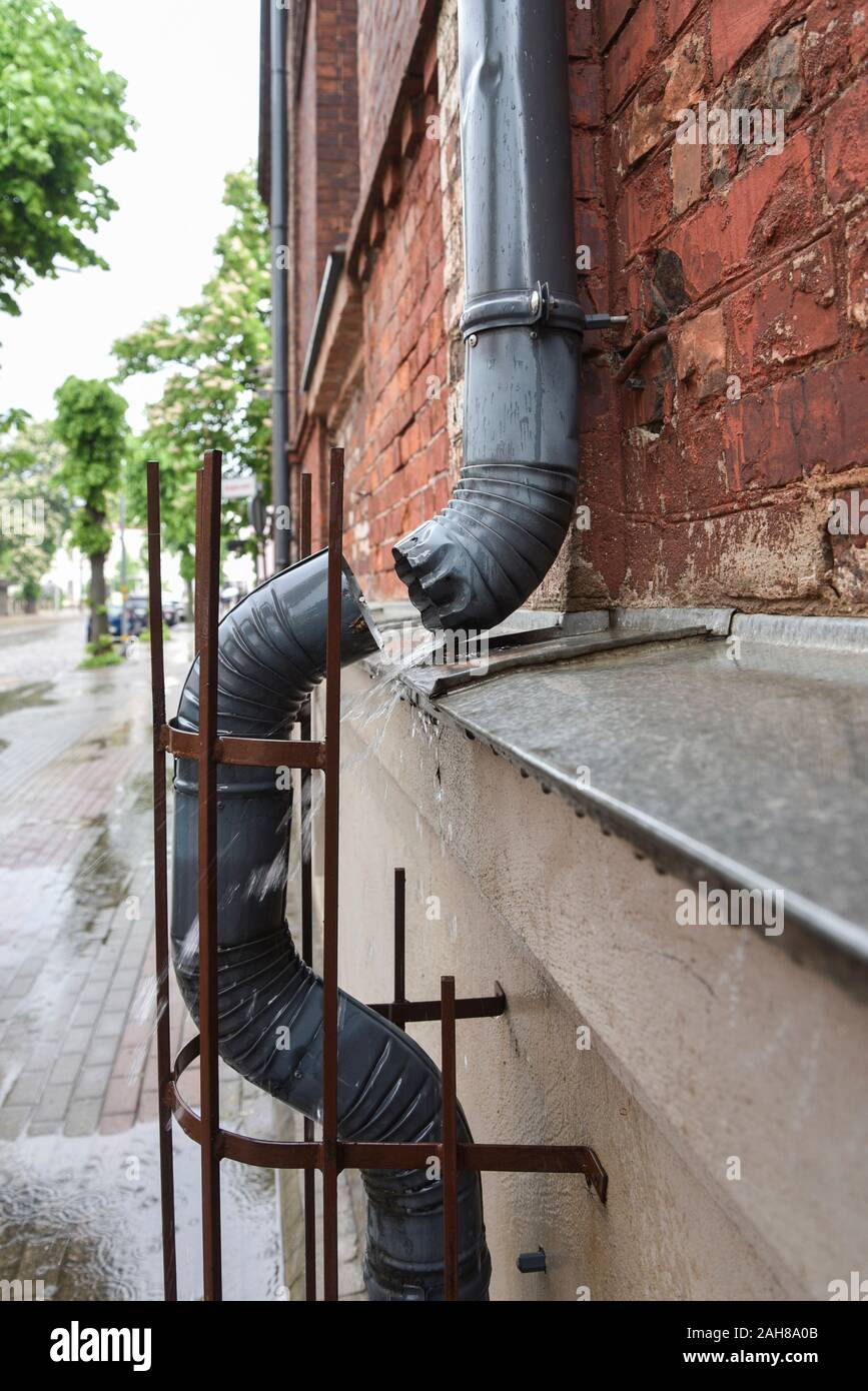 Rain water flowing from damage metal gutter Stock Photo - Alamy