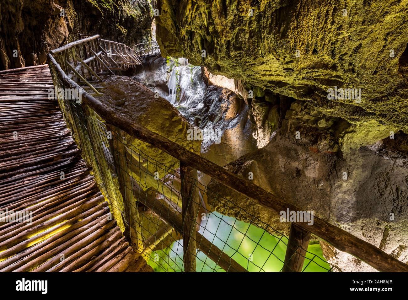 Wide angle view of a wooden catwalk leading into a gorge with green ...