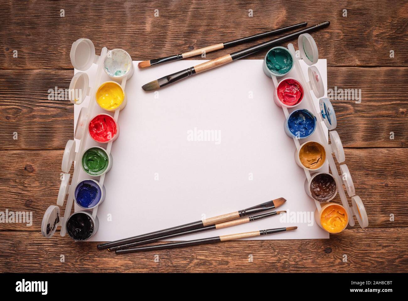 Empty white page with copy space, gouache jars and paint brushes on ...