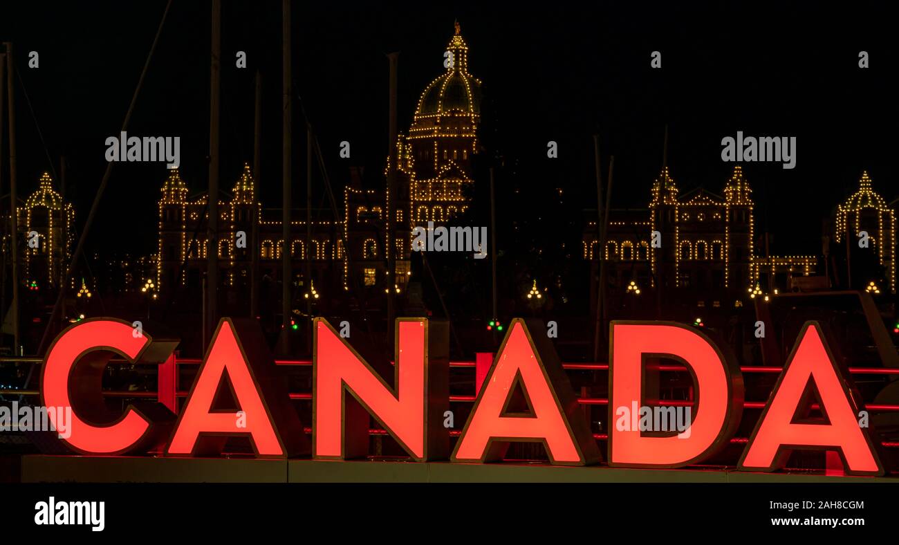 An illuminated Canada sign and the parliament building at the harbor in ...