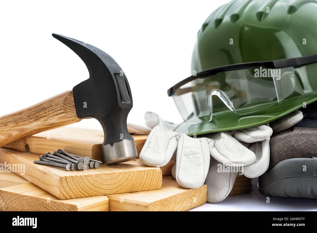 Close-up of a carpenter's hammer, helmet, goggles and protective gloves ...